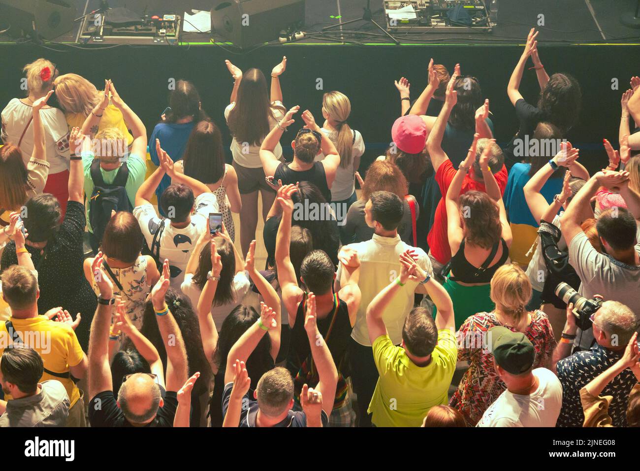 Crowd of spectators in front of the stage applauds the artist during at ...