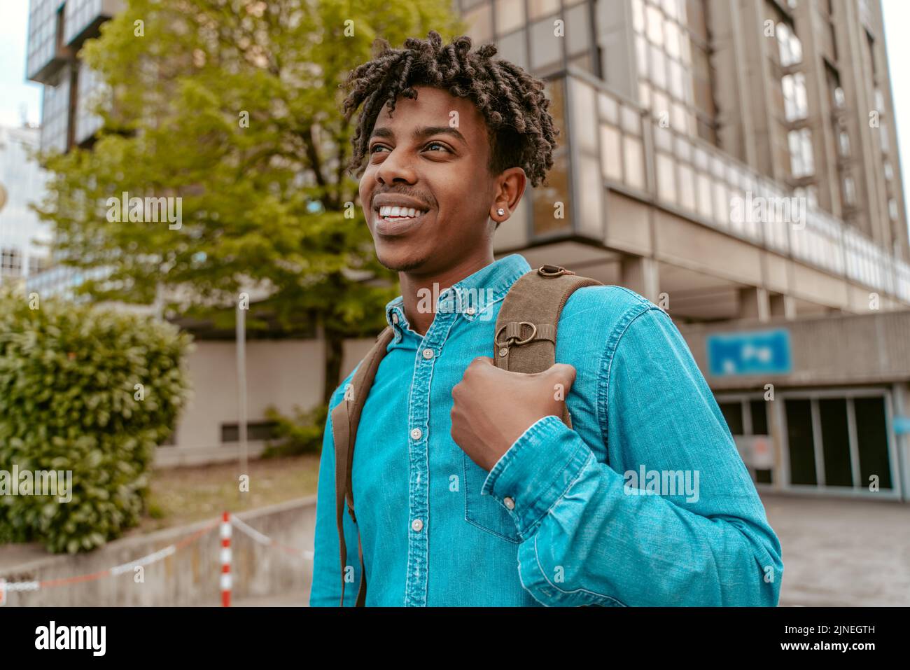 Smiling man walking on city street Stock Photo - Alamy