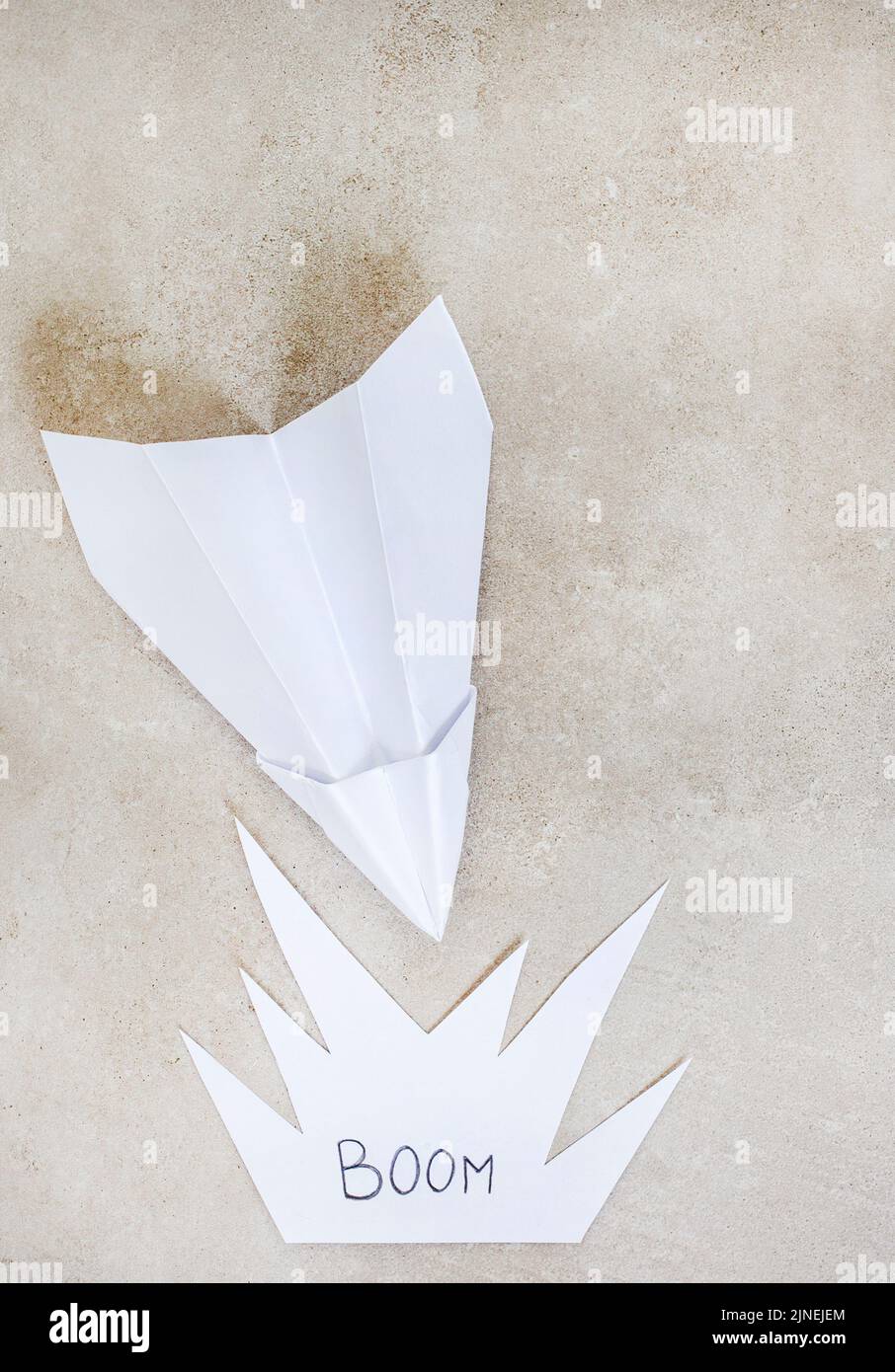 Paper airplane as metaphor, heading for a crash or explosion, on grey ...