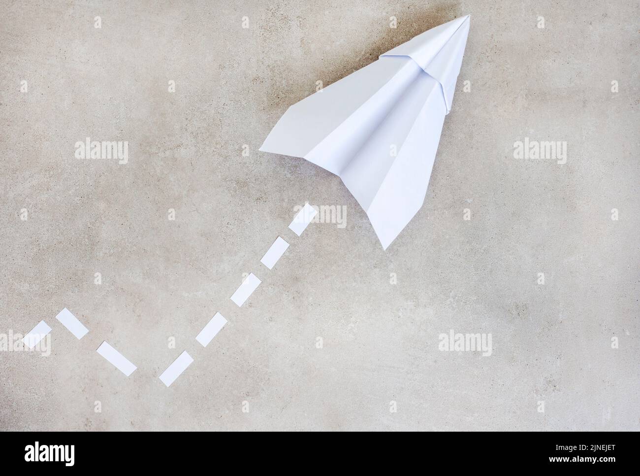 paper airplane as metaphor, taking off and rising, on grey with copy ...