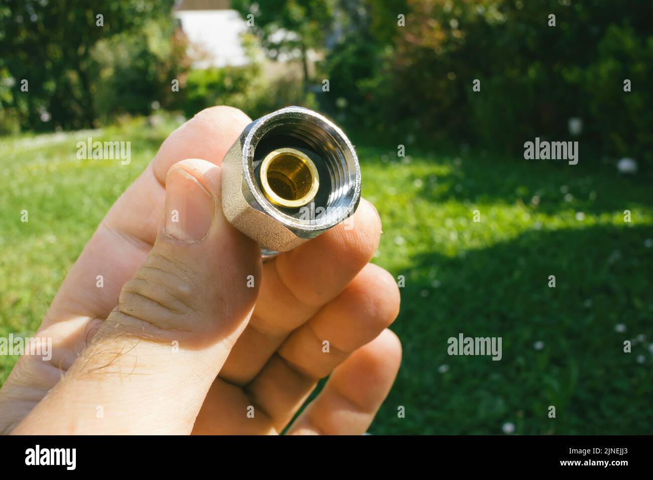 Gas metal hose part in male hand with green garden background Stock ...