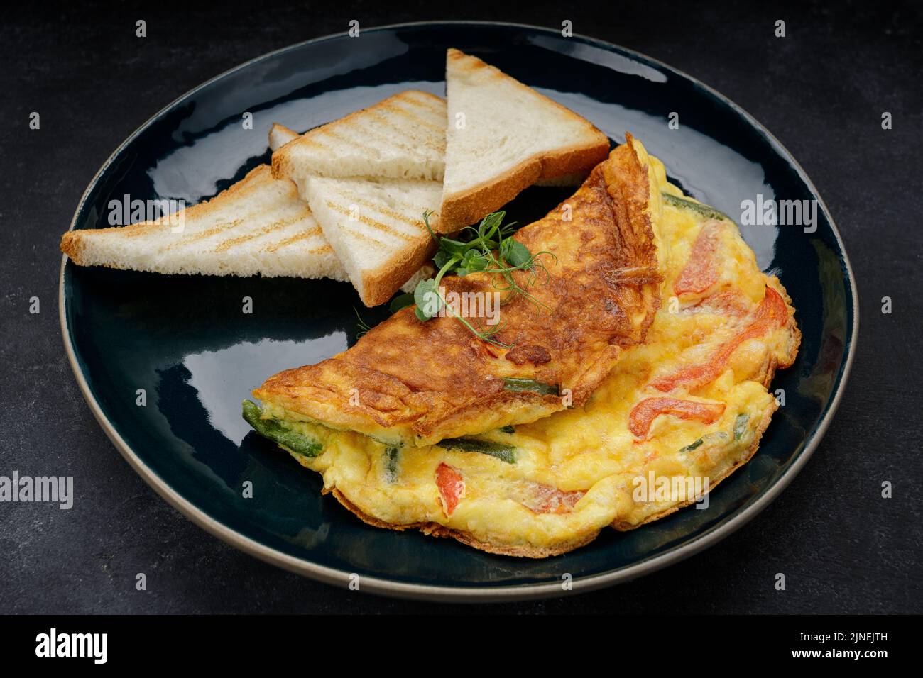 Omelet with vegetables and toast on a plate. Breakfast Stock Photo - Alamy