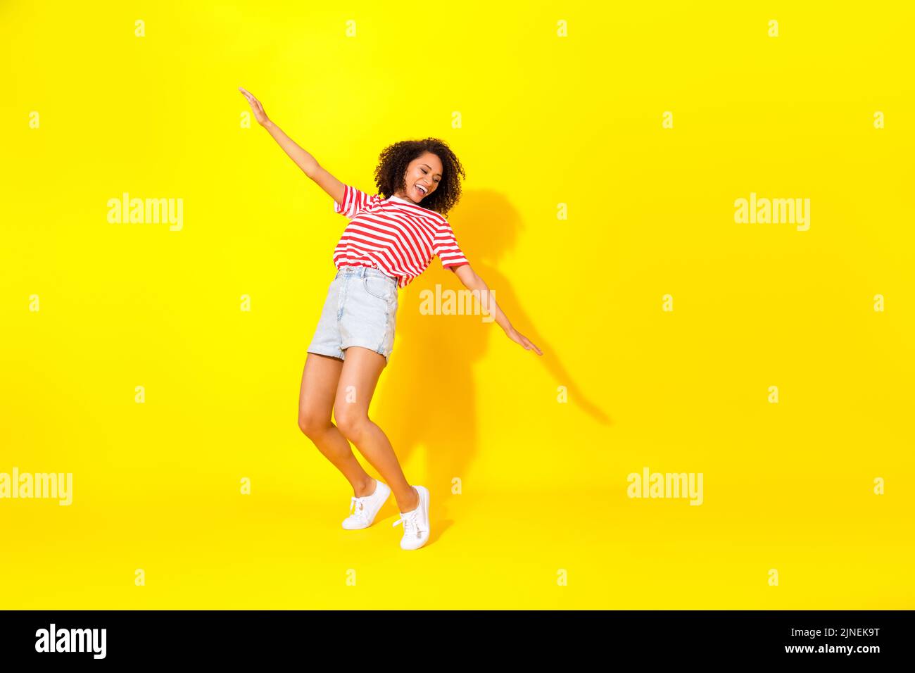 Full size photo of young smiling dancing lady hands wings looking empty ...
