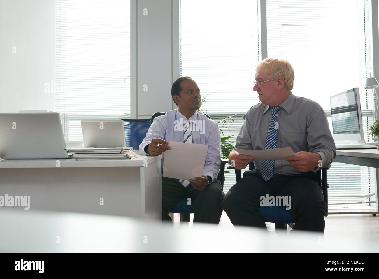 Employees discussing ideas for company development at business meeting ...