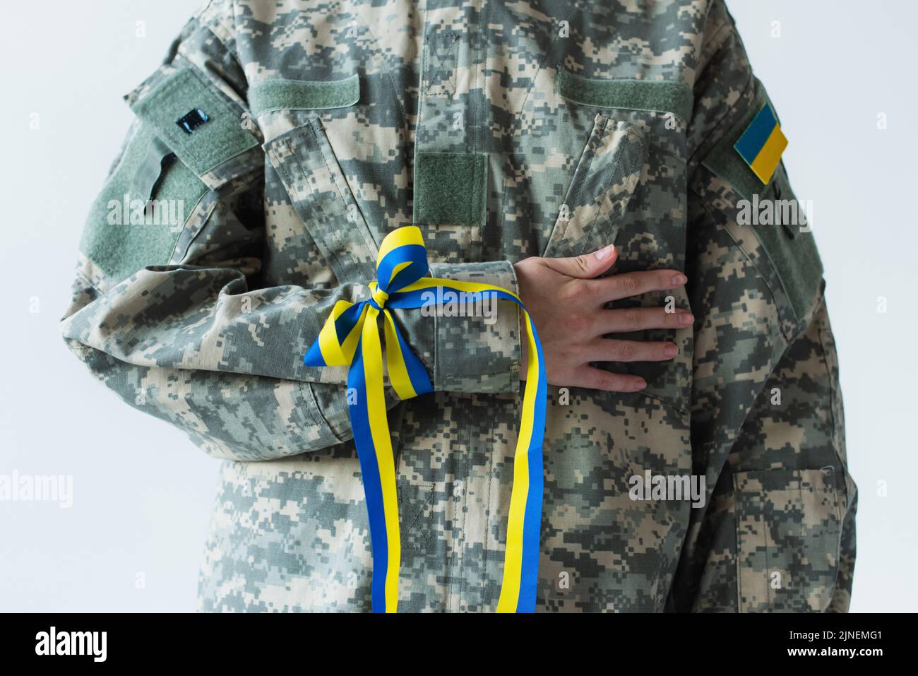Cropped view of soldier with ukrainian flag and blue and yellow ribbon ...