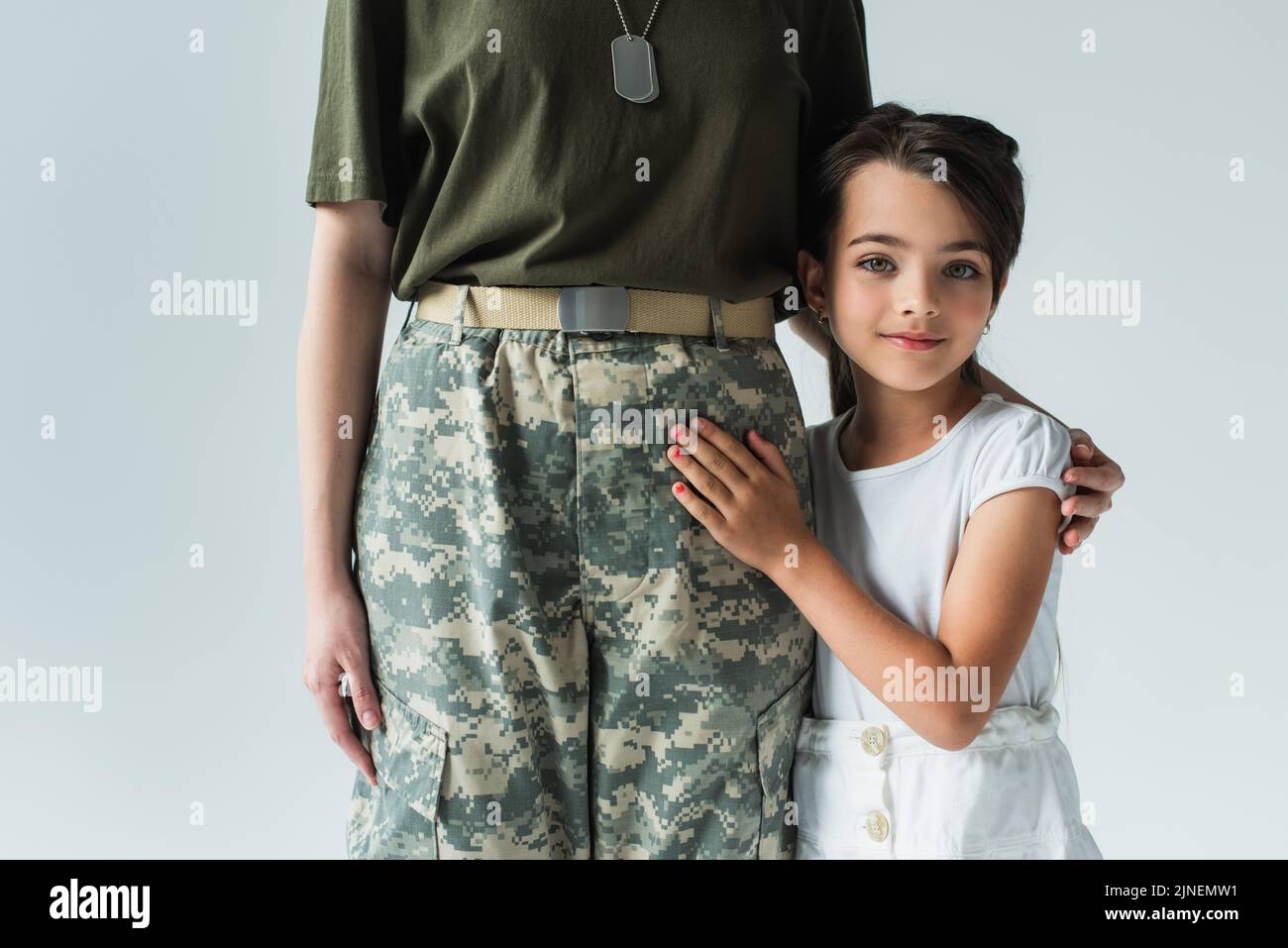 Soldier in uniform hugging smiling daughter isolated on grey,stock ...