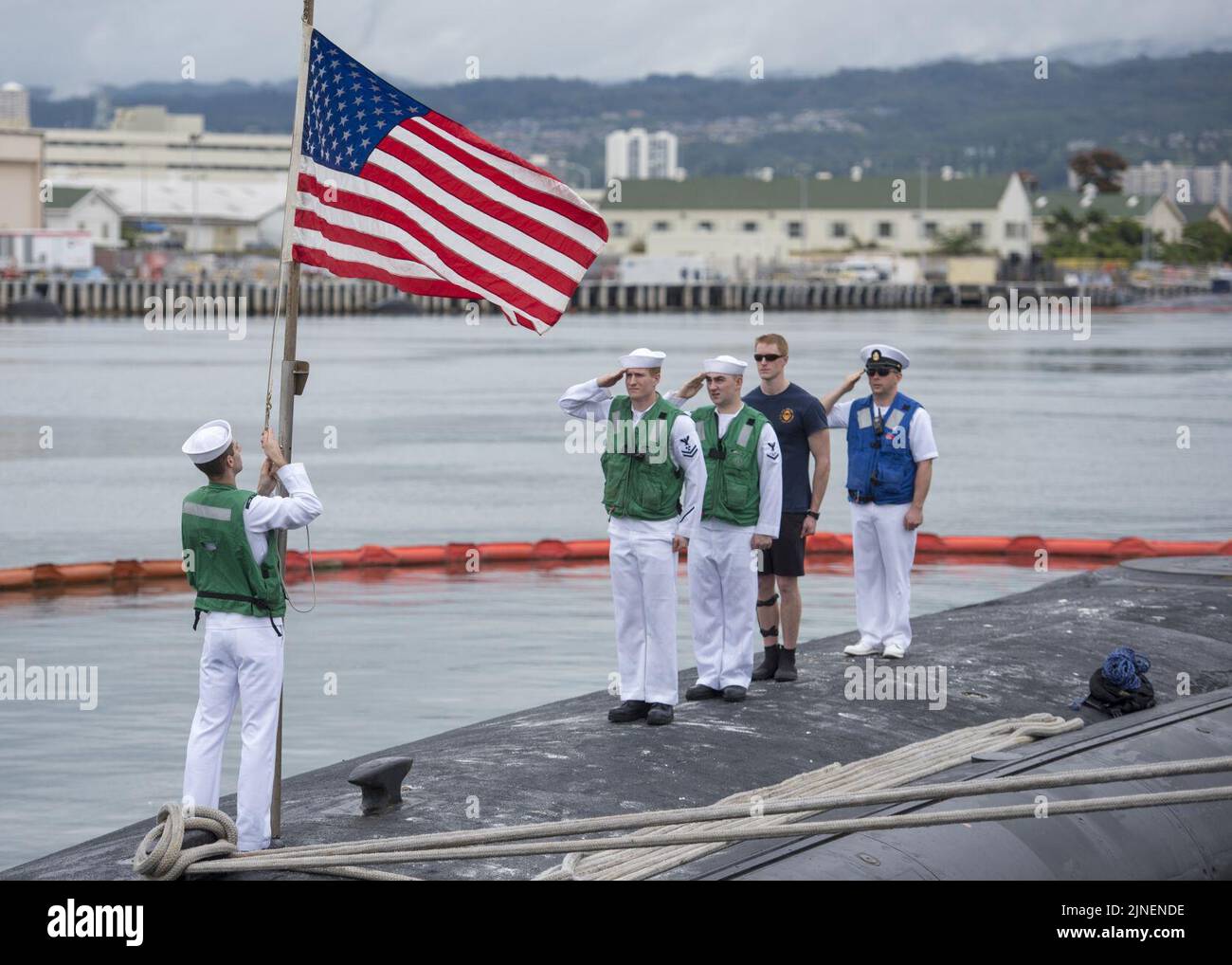 The crew of USS Texas render honors to the national ensign ...