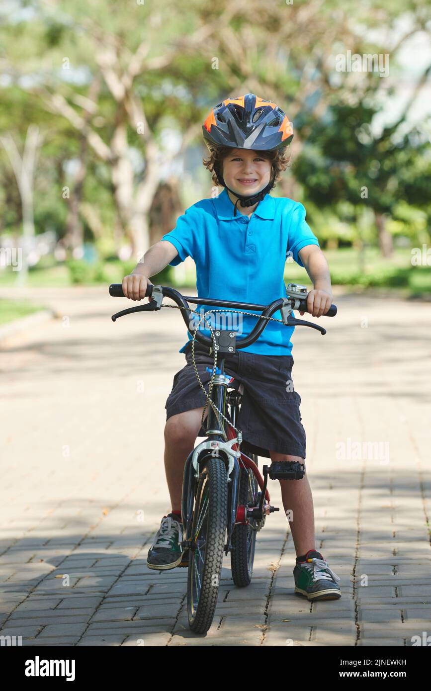 Cheerful happy boy riding on bicycle in helmet Stock Photo - Alamy