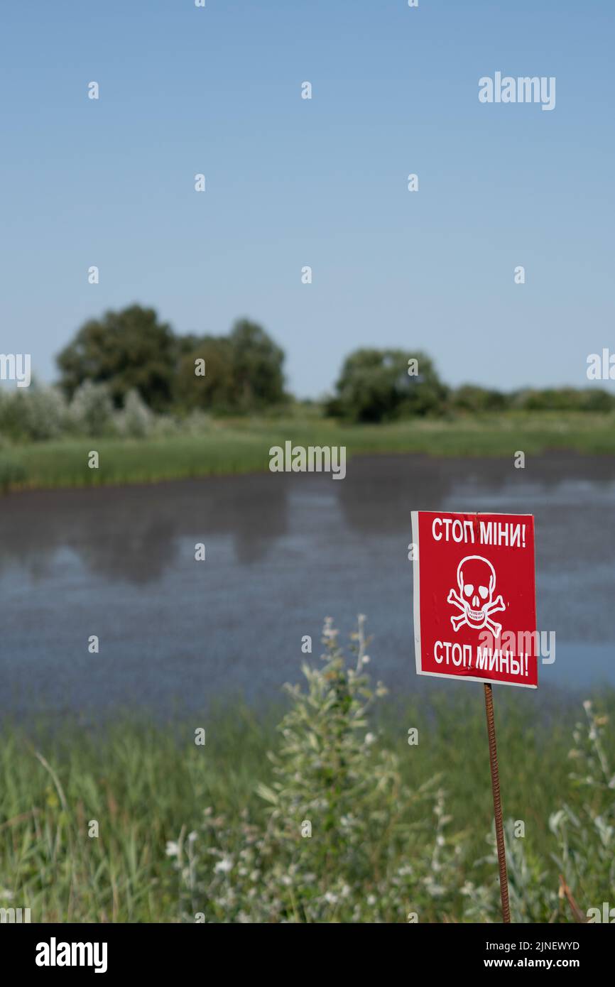 A sign caution stop mines on the riverbank Stock Photo - Alamy