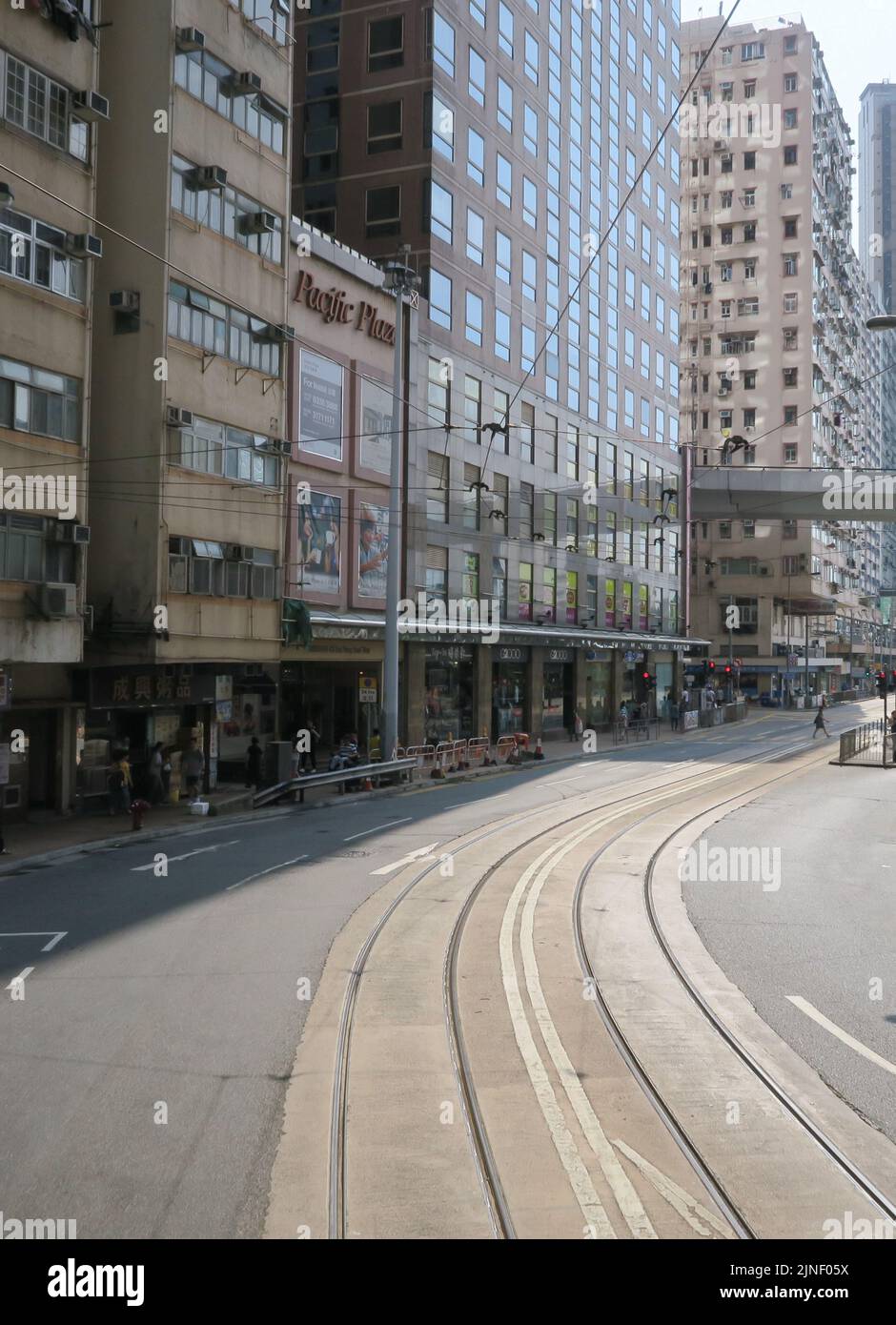 A vertical shot of the tram lines running down a street in central Hong ...