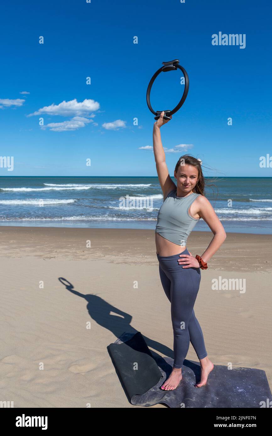 beautiful athlete posing with pilates ring at the beach Stock Photo - Alamy