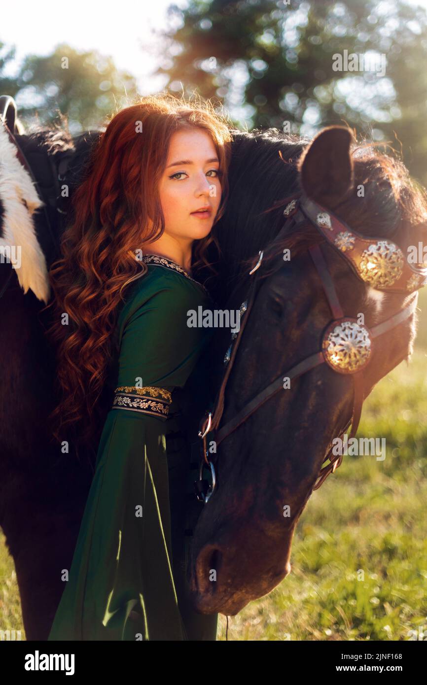 Medieval woman princess in green dress sits astride black steed horse ...