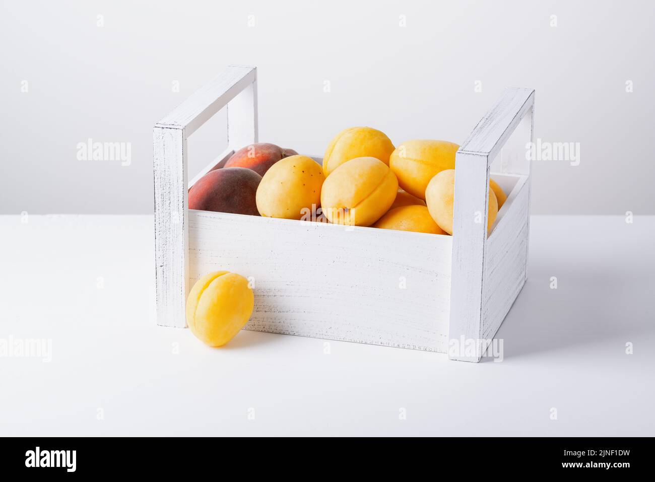 Wooden box with apricots and peaches isolated on white background Stock ...