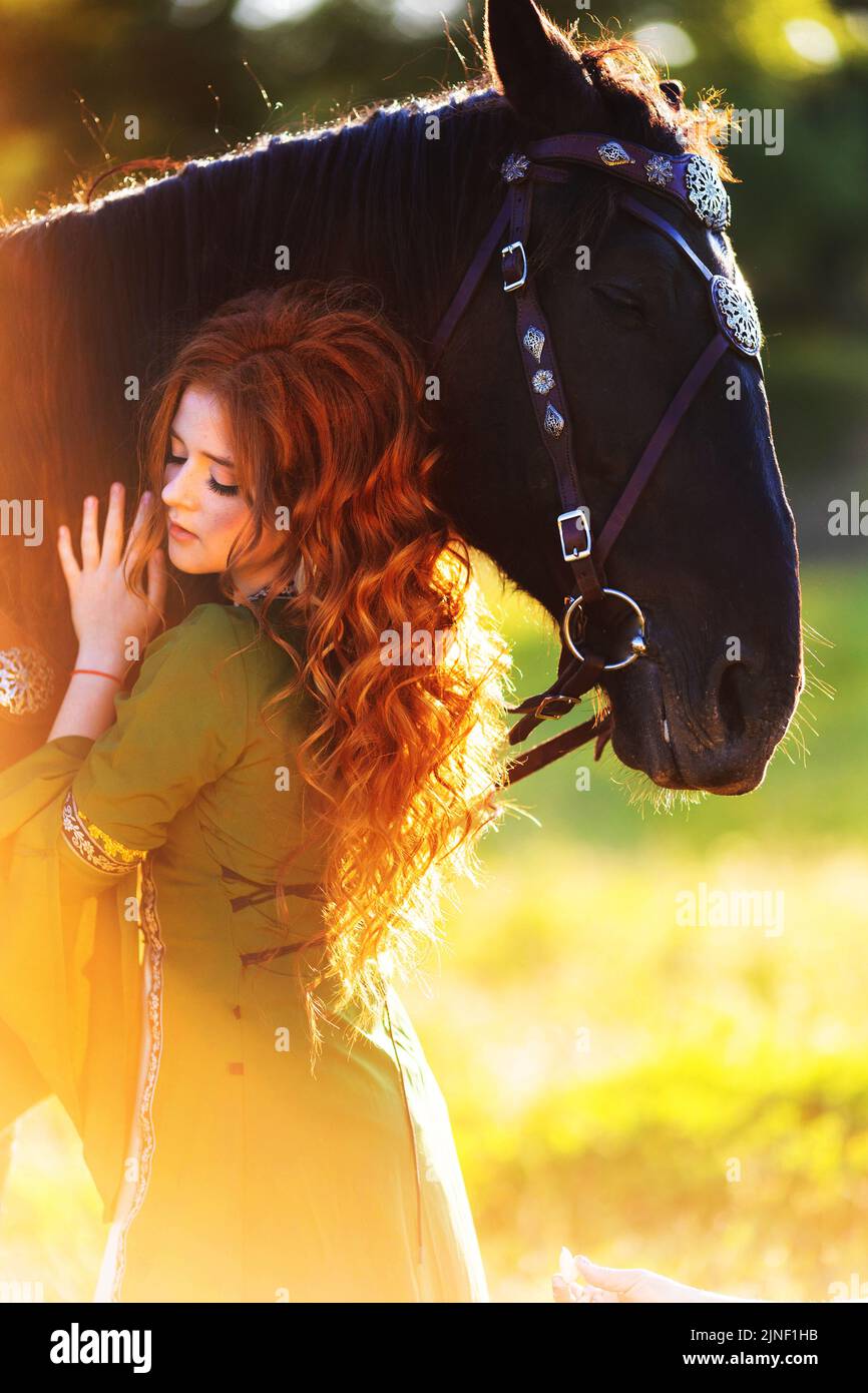 Medieval woman princess in green dress sits astride black steed horse ...