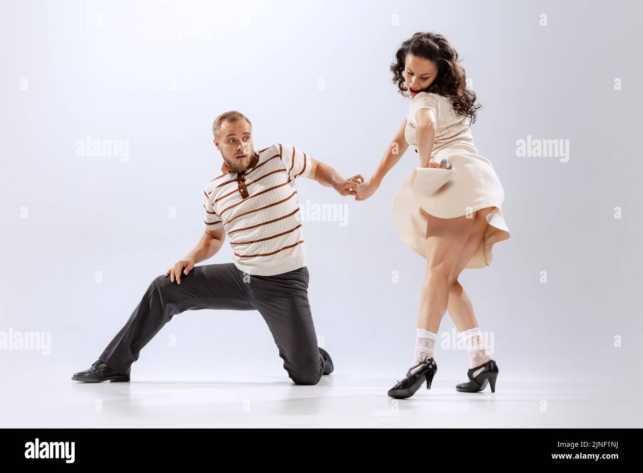 Rhythm and expression. Energetic dance couple in retro style outfits dancing lindy hop, jive ...