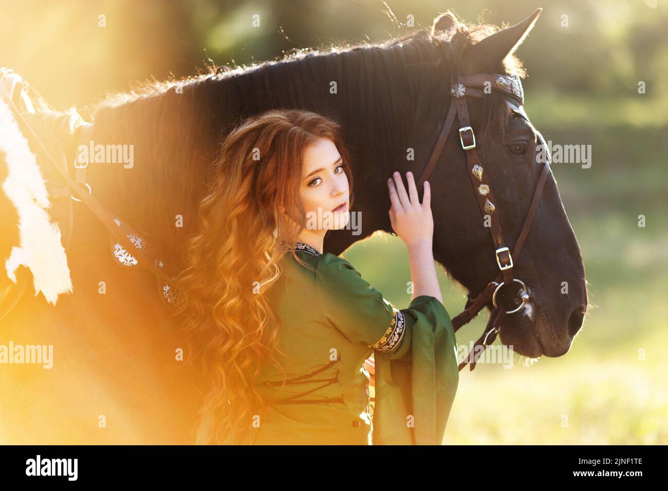 Medieval woman princess in green dress sits astride black steed horse ...
