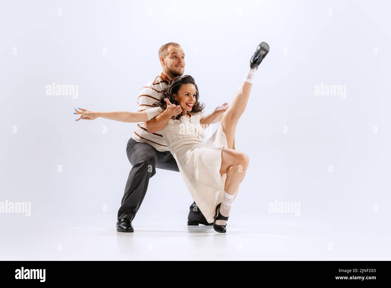 Thrilled dance couple in vintage outfits dancing lindy hop, jive ...