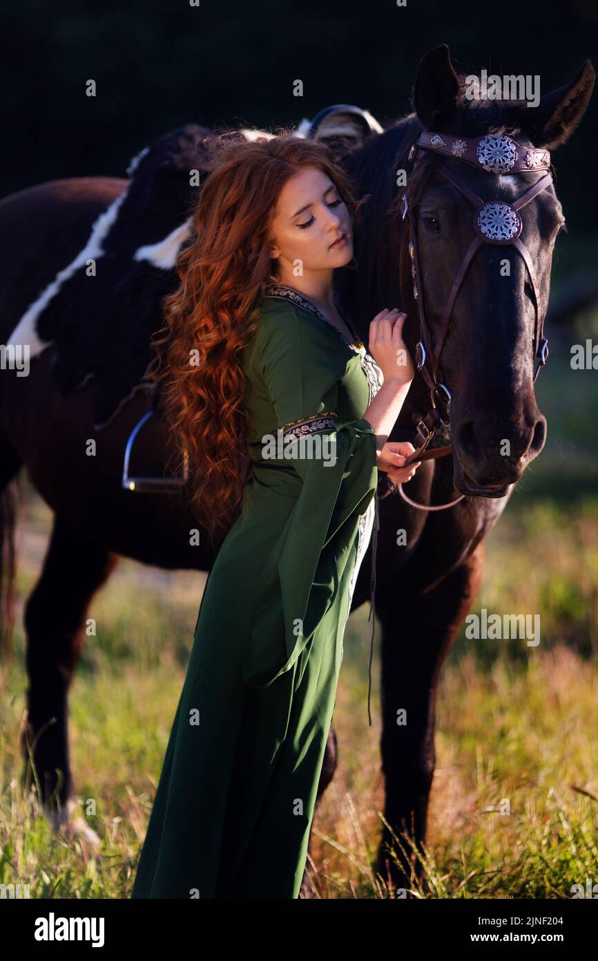 Medieval woman princess in green dress sits astride black steed horse ...