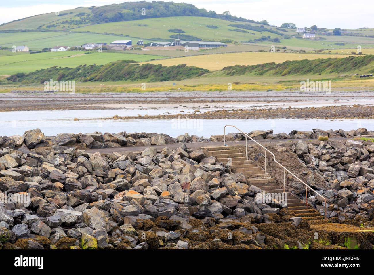 Steps leading down from a rocky harbour wall at low tide Stock Photo ...