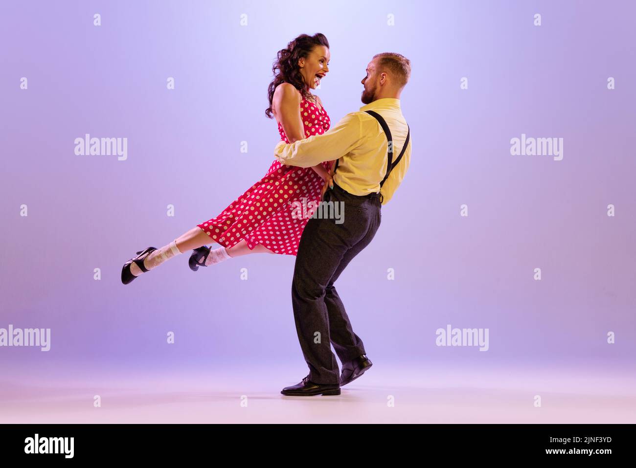 Active and emotional couple in colorful retro style costumes dancing ...