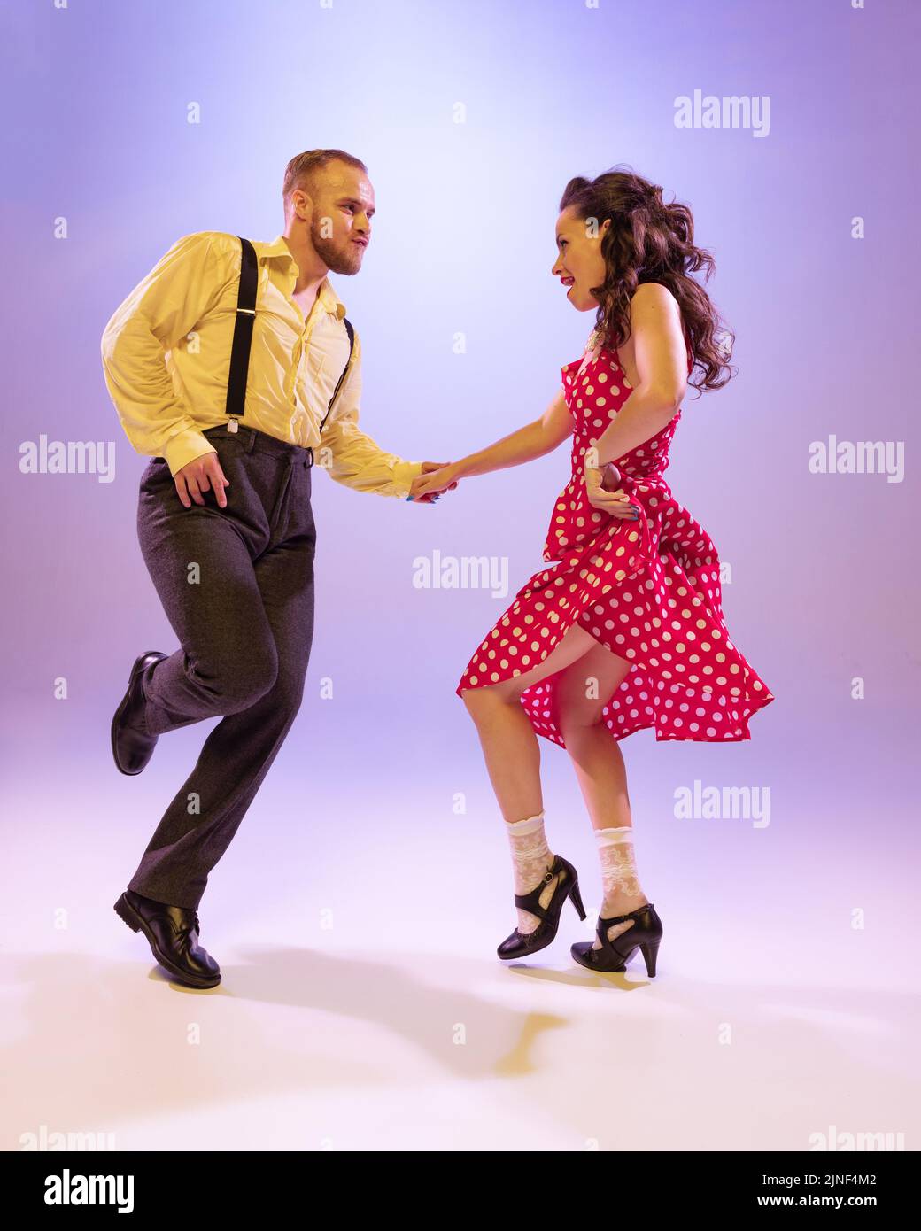 Active and emotional couple in colorful retro style costumes dancing ...