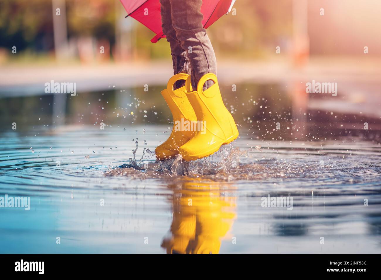 Kid child jumping puddle water splash hi-res stock photography and ...