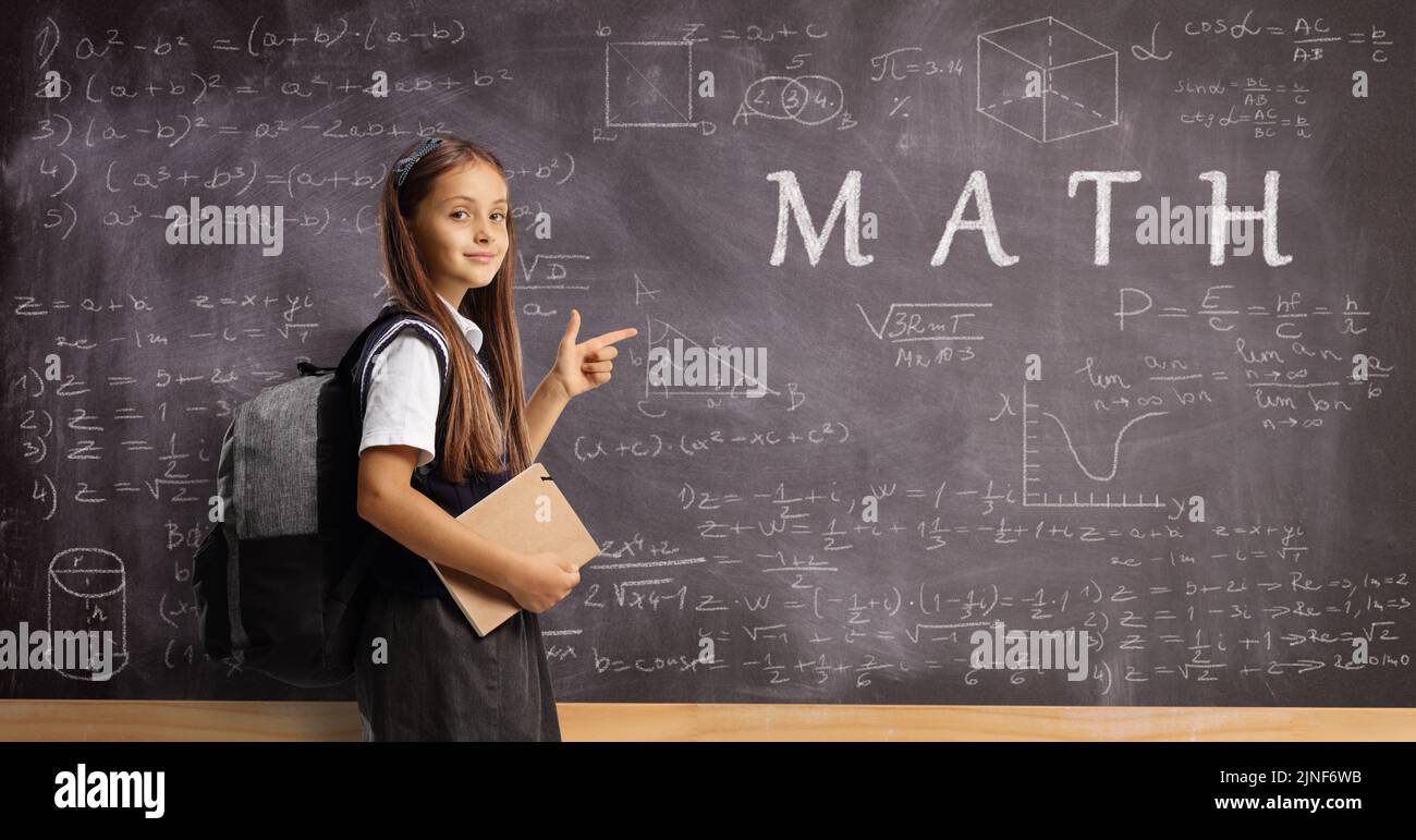 Child in school uniform with a backpack and book pointing at a ...