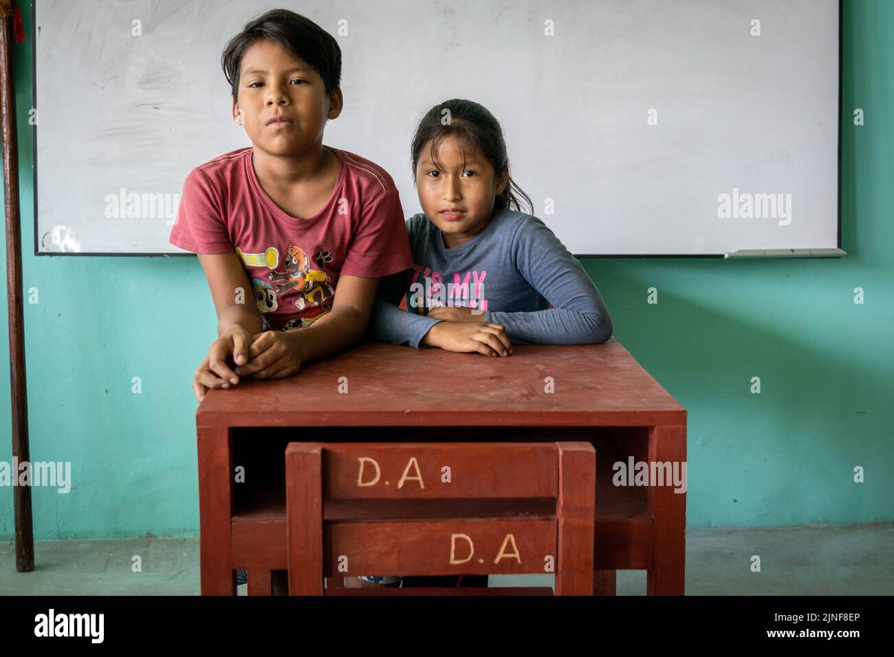 Riberenos students pose behind a donated desk and chair at their school ...