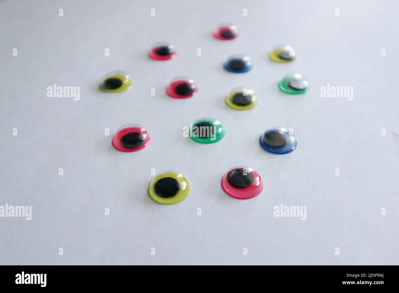 Blue pink red yellow green googly eyes made of plastic on white ...