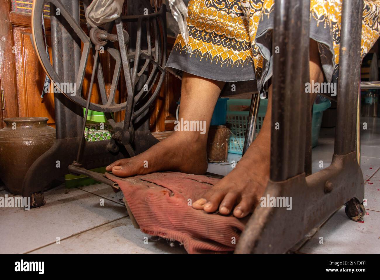 Close up view of a woman's legs while working on an old mechanical ...