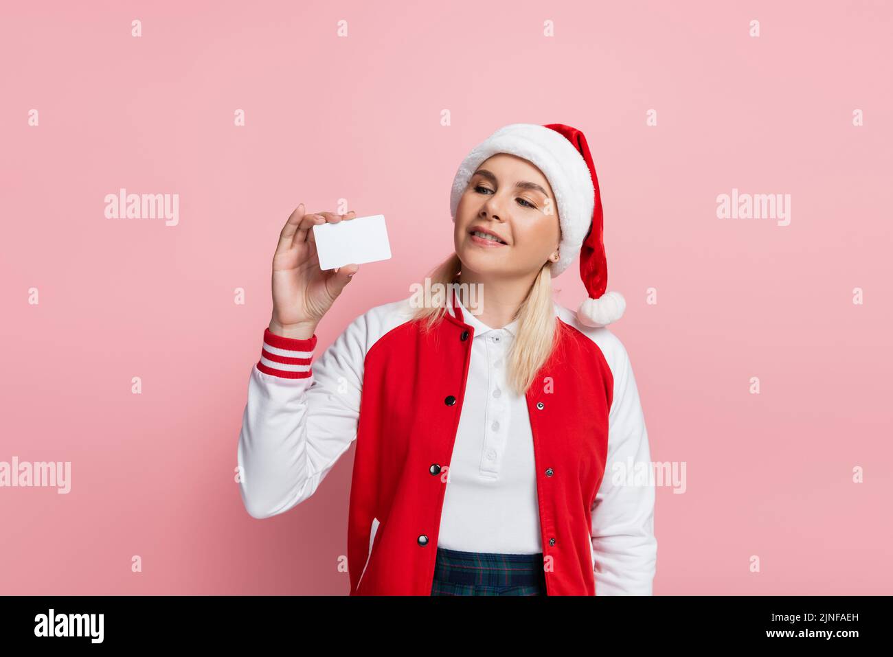 Blonde woman in red santa hat holding empty driving license isolated on ...