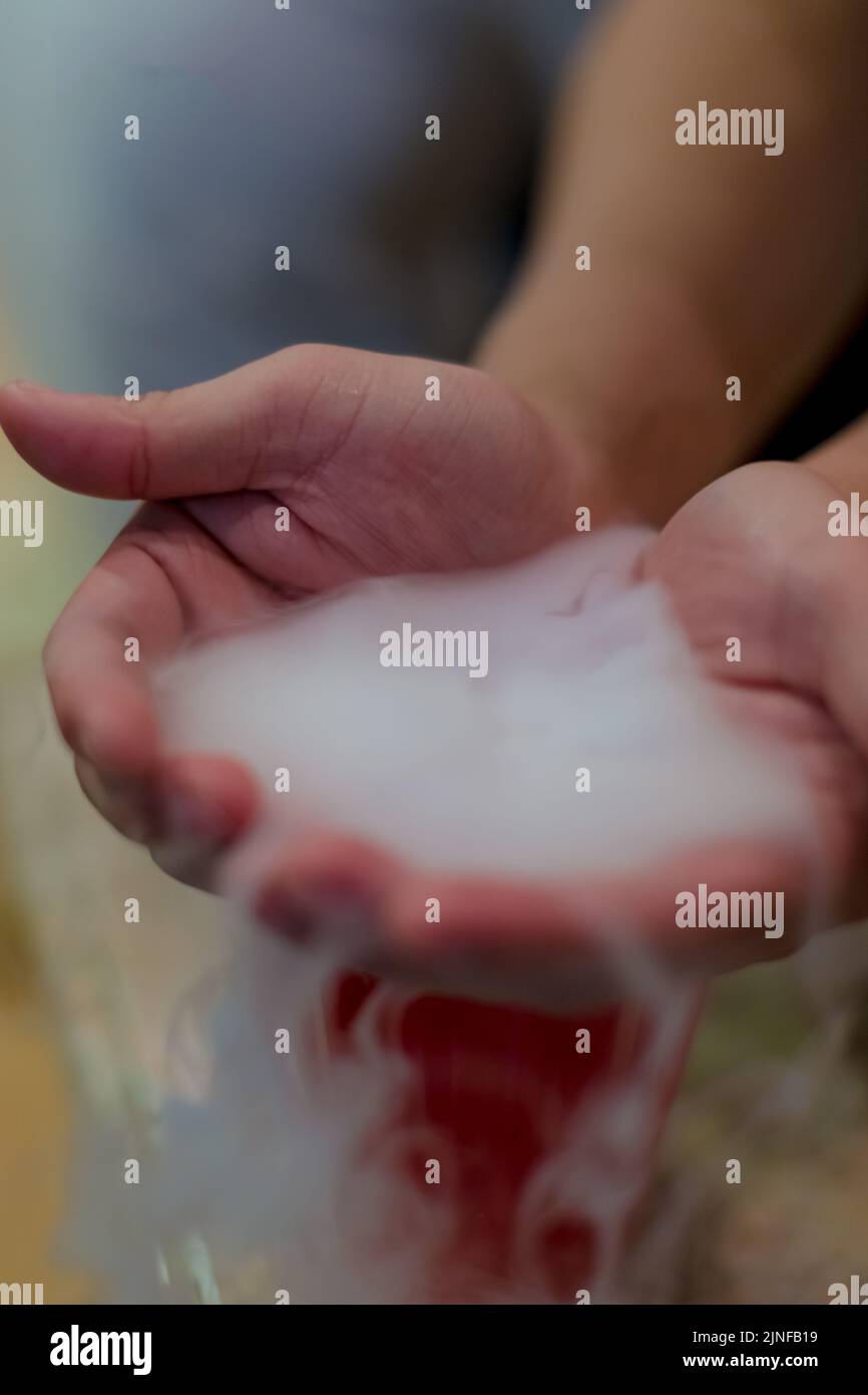 A vertical closeup of dry ice fog in hands Stock Photo - Alamy