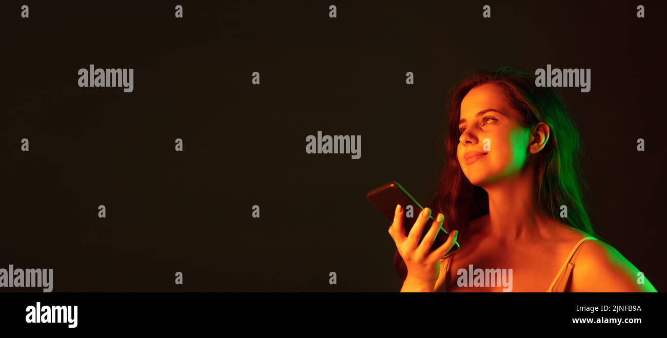Portrait of beautiful young woman recording voice message isolated over ...