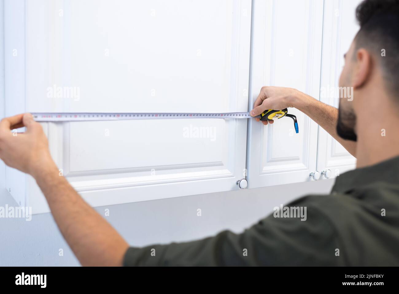 Blurred muslim man measuring kitchen cabinet at home,stock image Stock ...