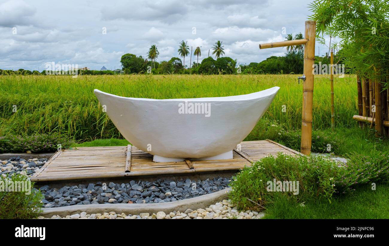 white bathtub outside looking out over a green rice field, bath tub ...