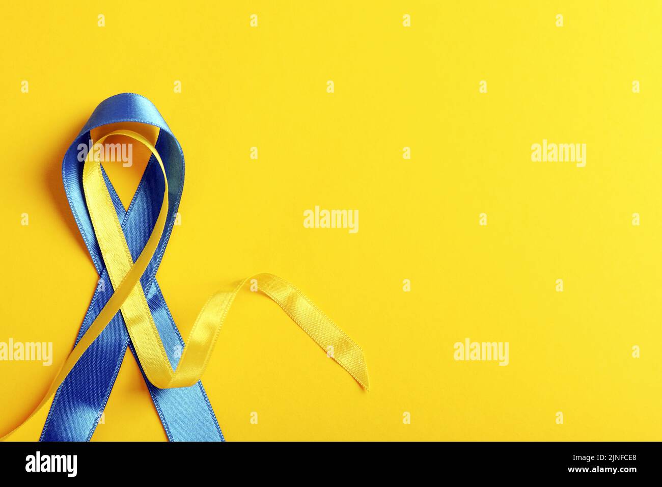 The yellow and blue ribbons on a yellow background with copy space ...