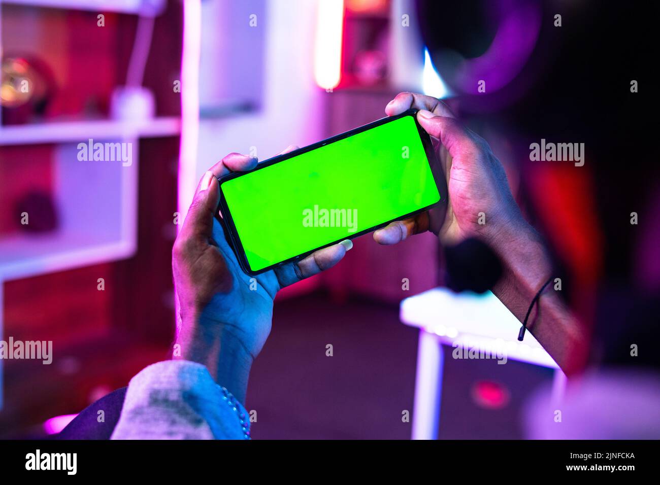 Close up shot of gamer playing video game on green screen mobile phone ...