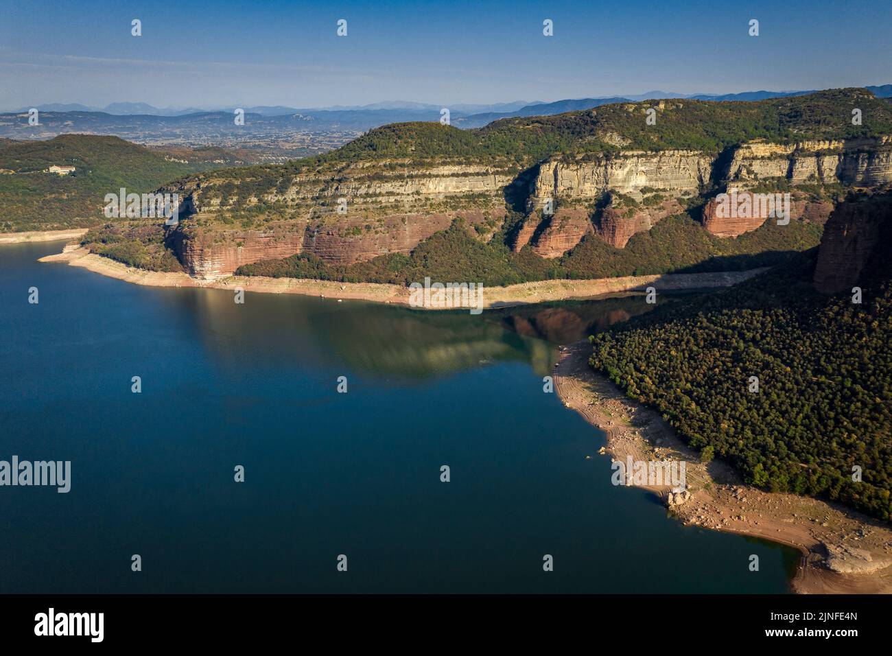 Aerial view of the bell tower of Sant Romà de Sau and the Sau reservoir ...