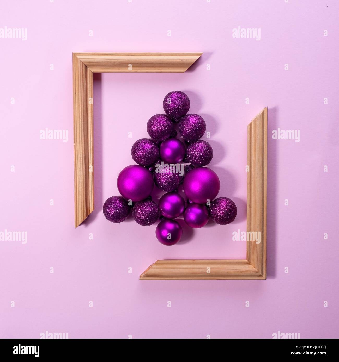 Christmas decorations lined Christmas tree on a pink background in a ...