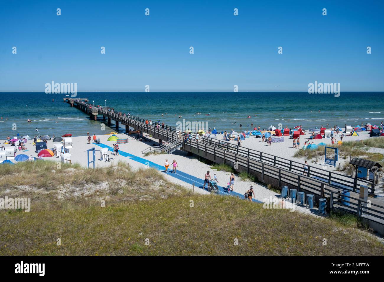 Prerow, Germany. 11th Aug, 2022. Tourists walk on the pier on the beach ...