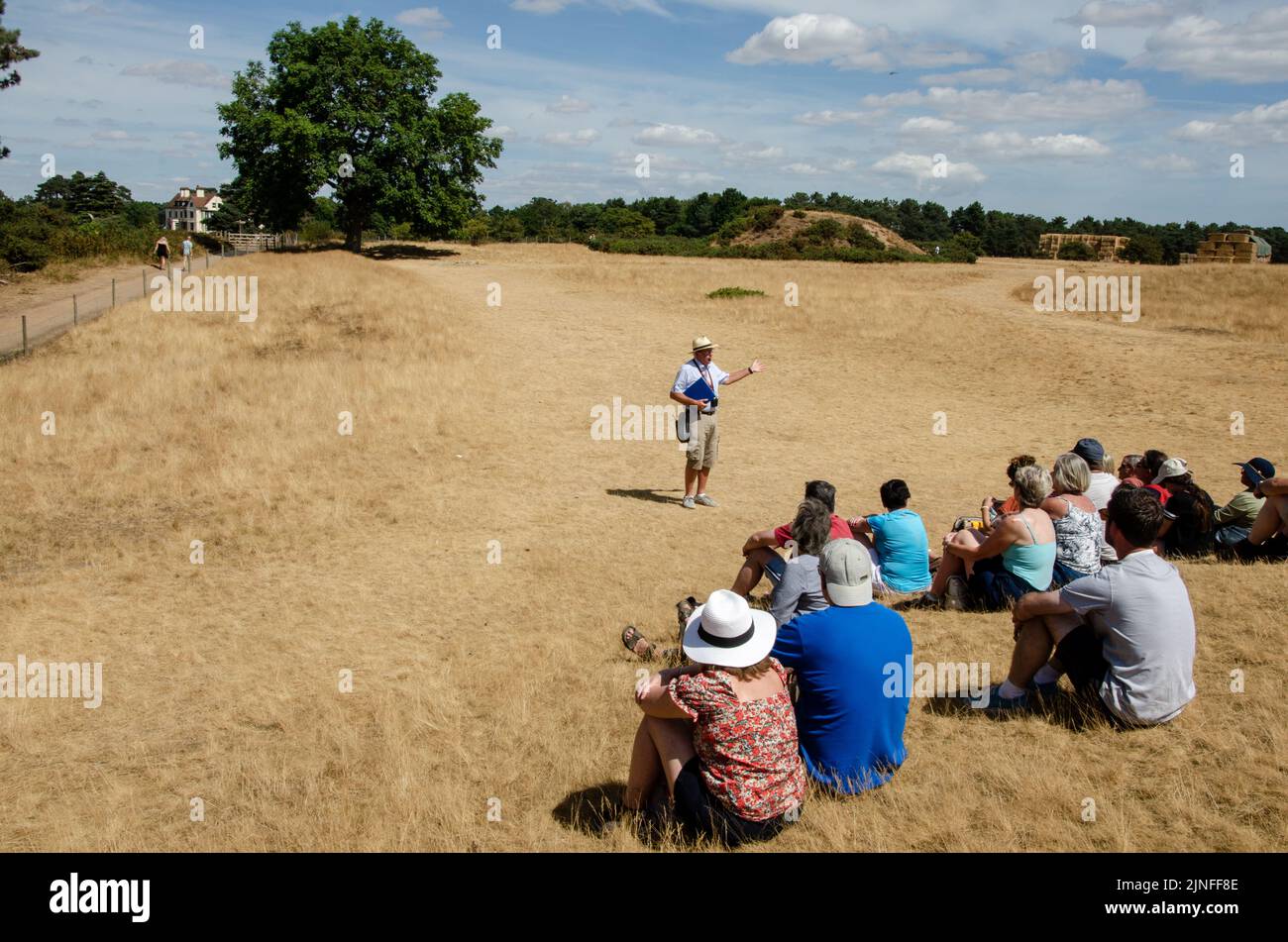 Guide speaking to tourists at the site of the Anglo-Saxon burial gounds ...