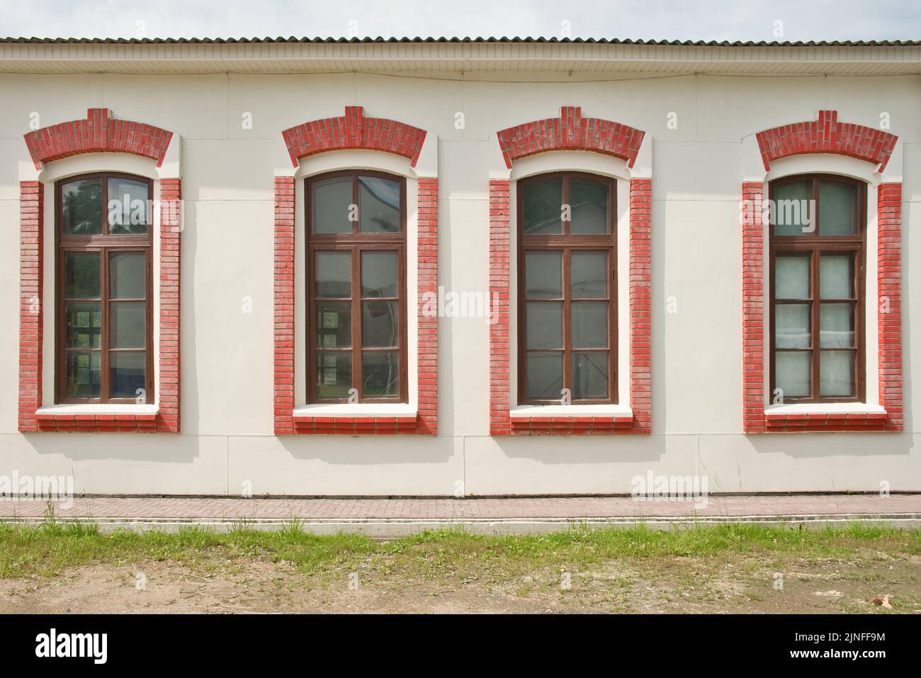 Four tall windows with brick frames in a row. Facade of one-storey ...