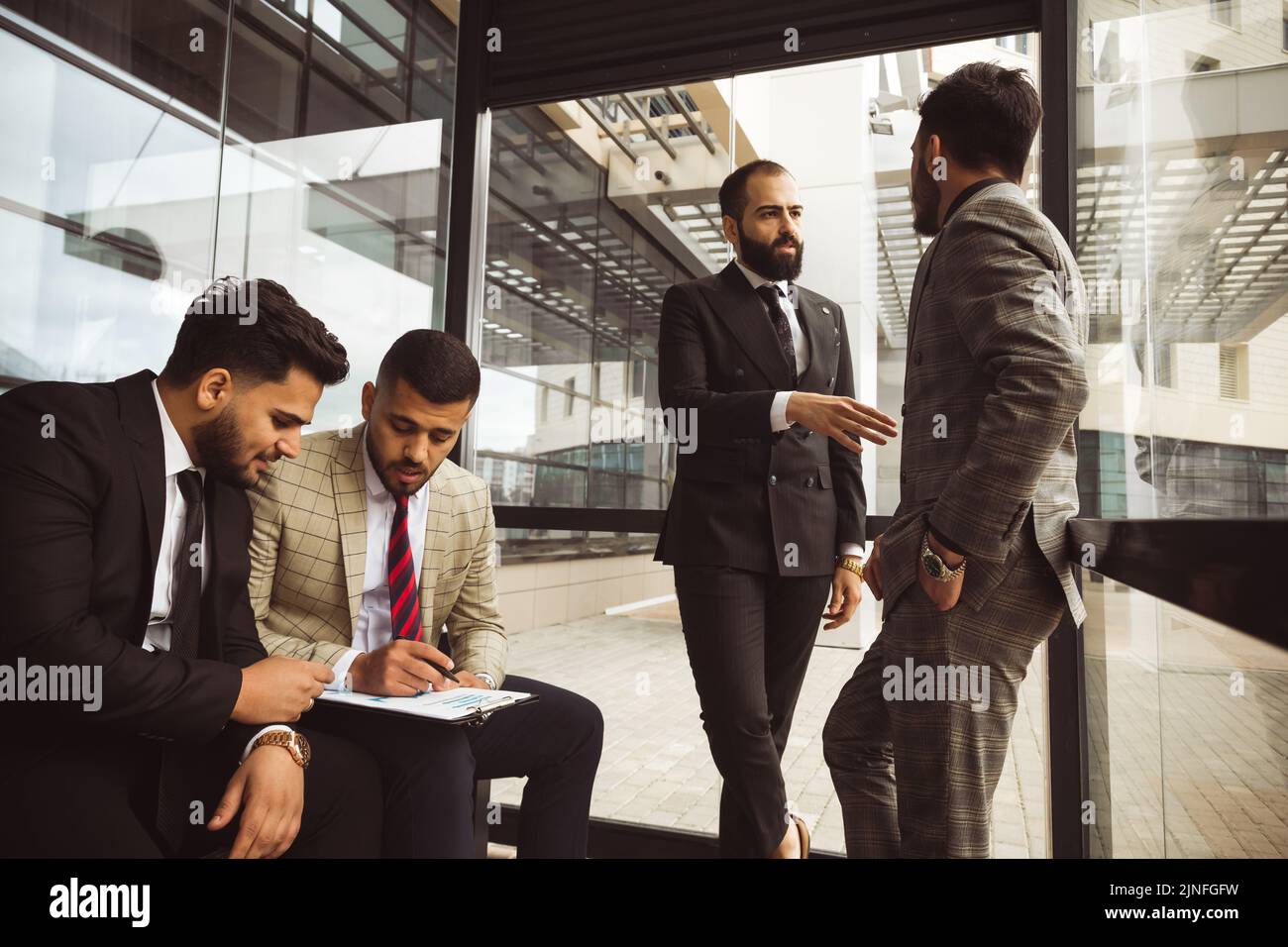 An international team of successful young business men in suits at a ...