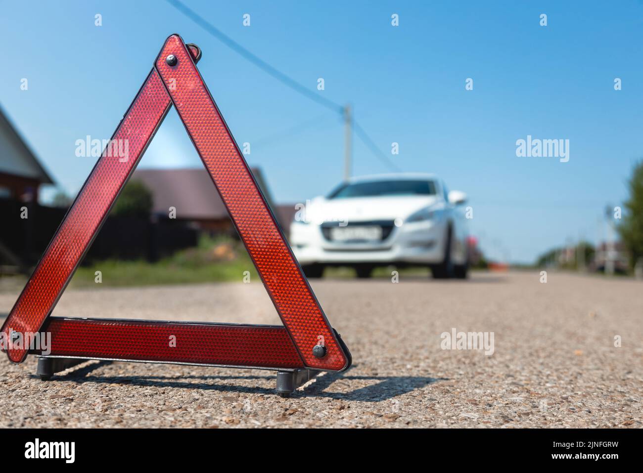 Car breakdown concept. Warning stop triangle close-up on the background ...