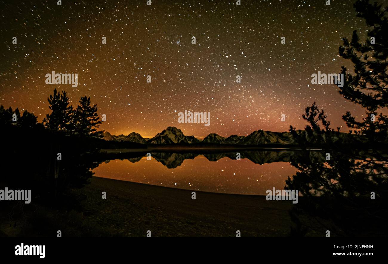 A stunning view of a Starry night with Grand Tetons on the background ...