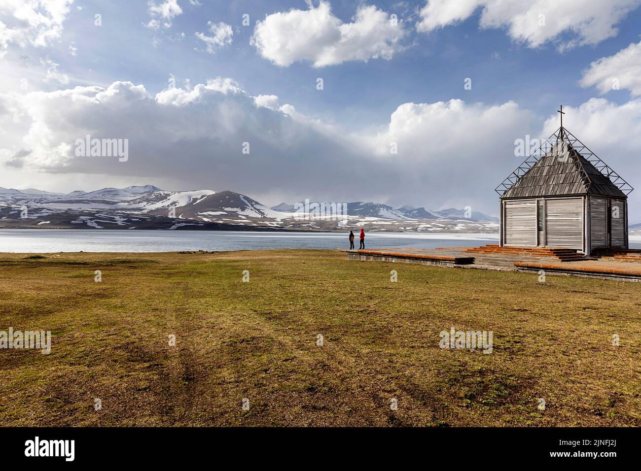 Tourists at the Small church looking at the beautiful and frozen lake ...