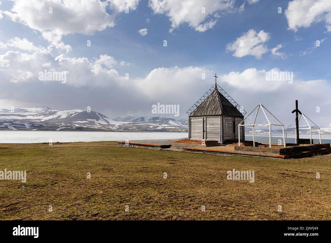 Small church by the beautiful and frozen lake Paravani in spring ...