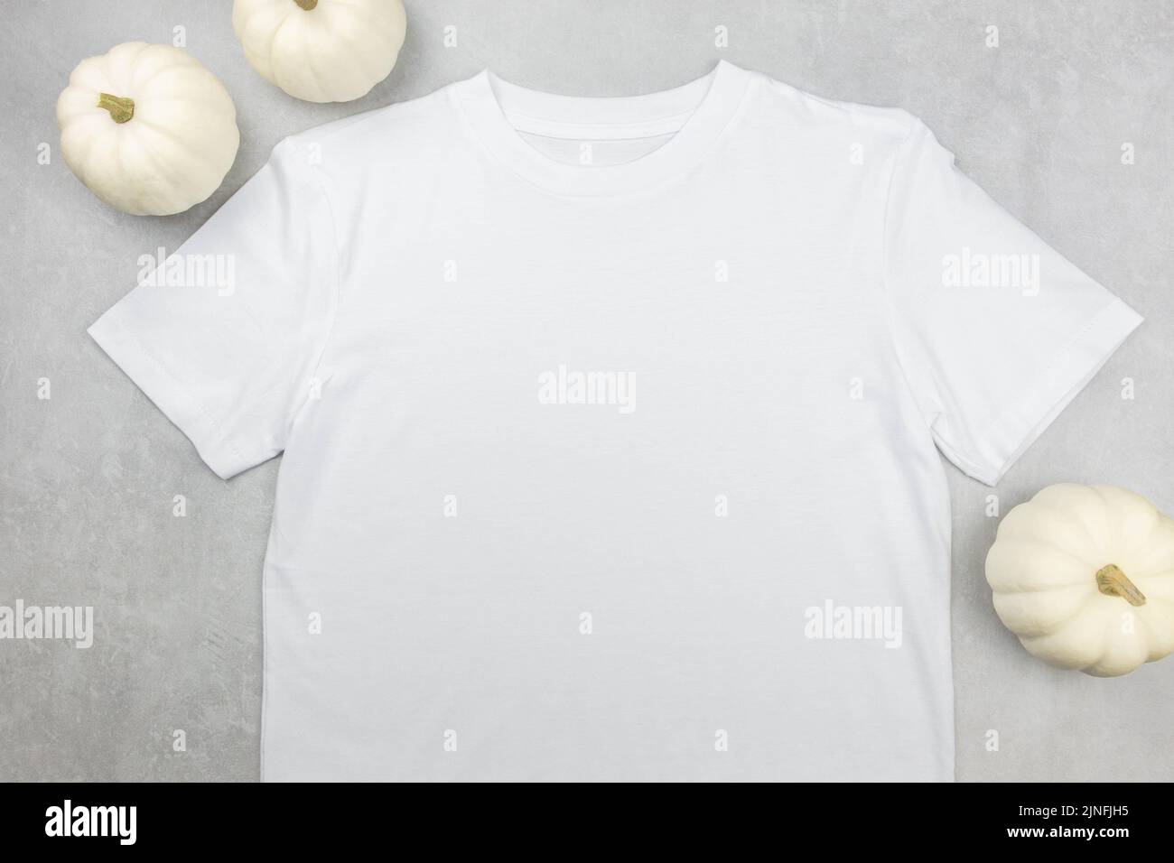 White Womens Cotton T Shirt Mockup With Pumpkins On Gray Concrete
