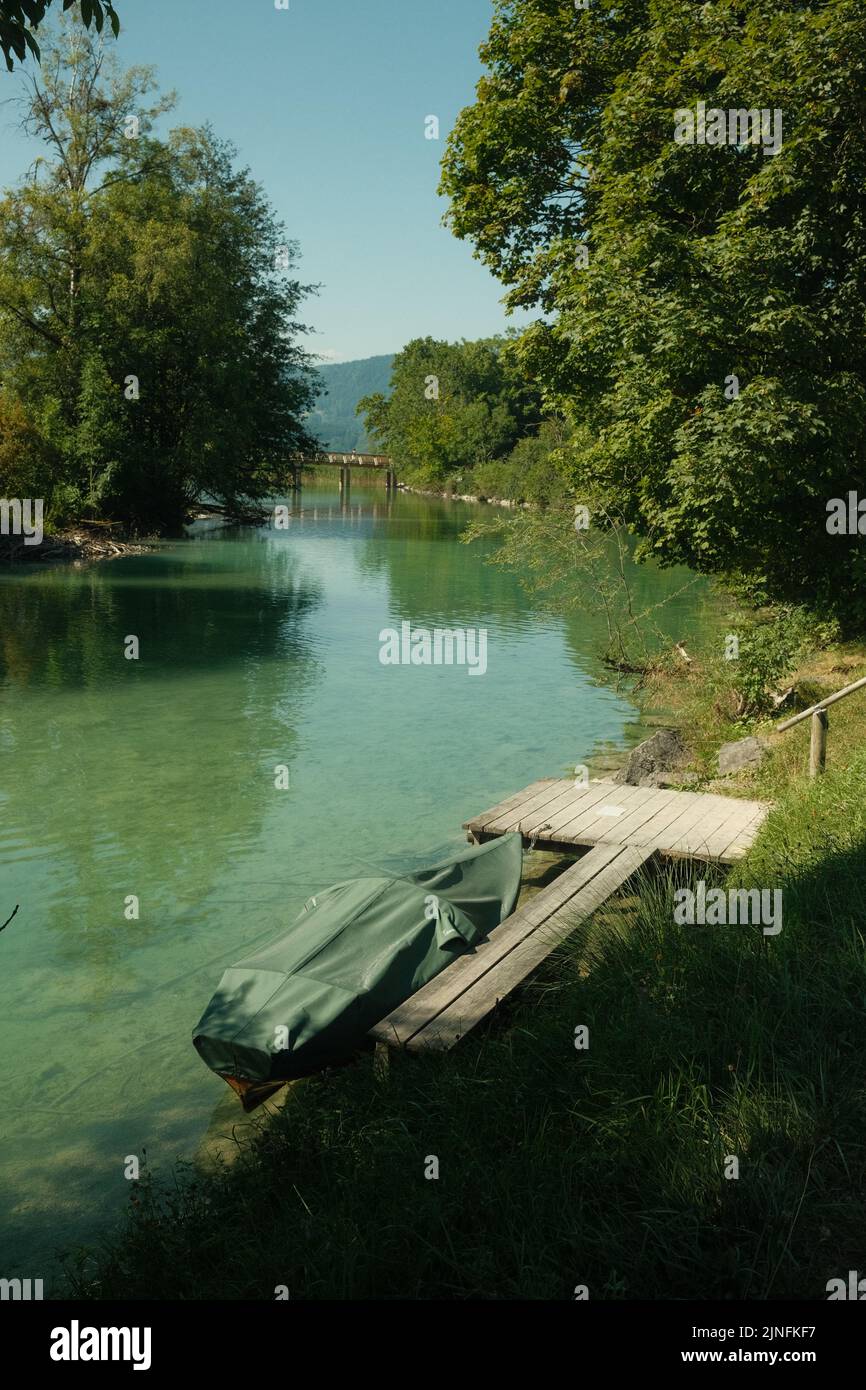 A jetty with a covered boat beside it near the crystal-clear water at ...