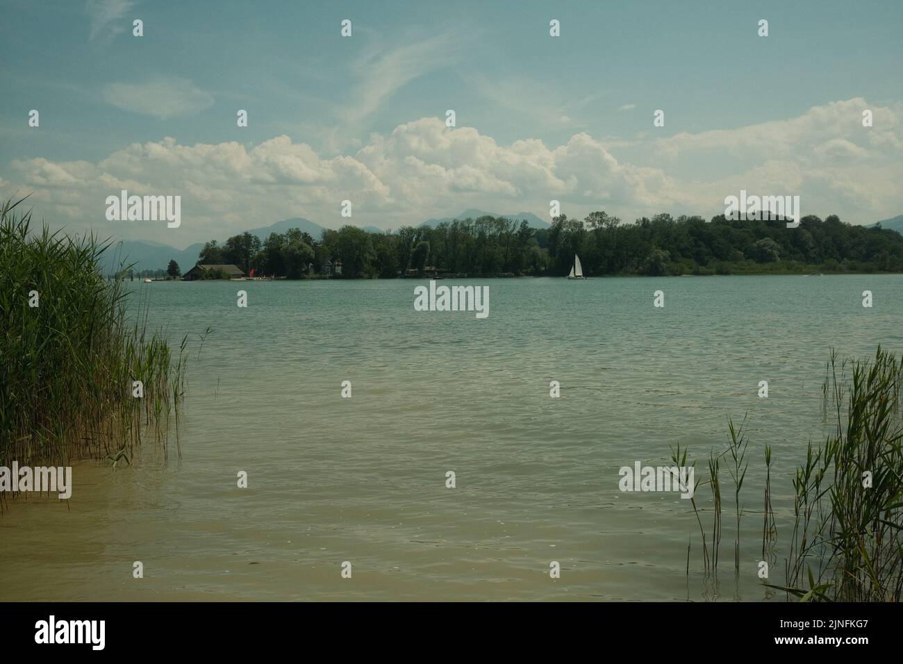 A gorgeous view of the Chiemsee with a sailing boat going across it ...